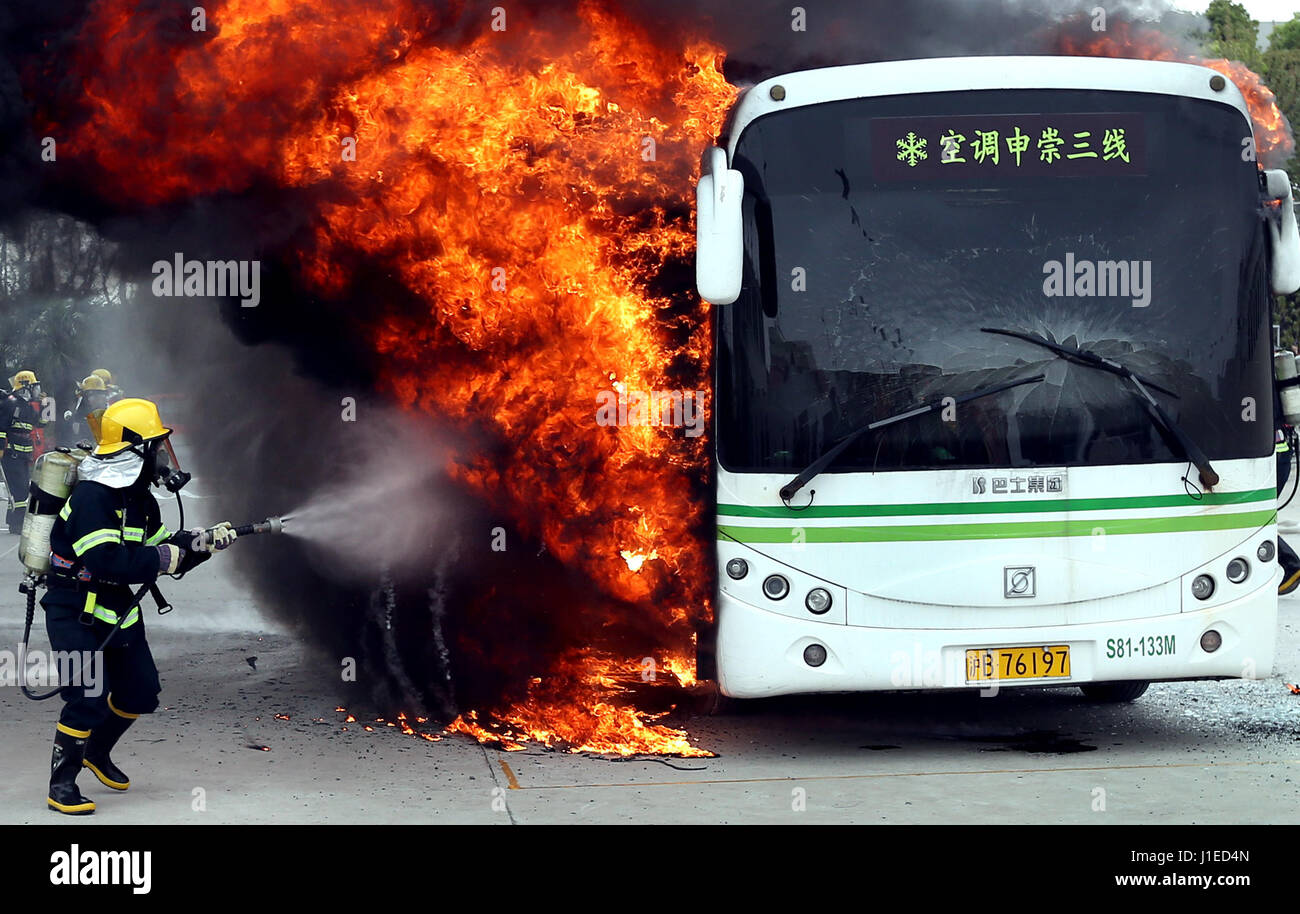Shanghai, China. 21st Apr, 2017. Firemen extinguish the flames on a bus ...