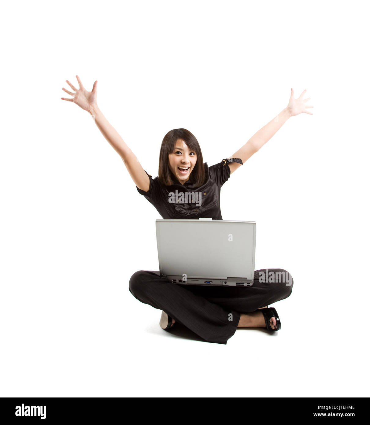 A happy woman raising her arms while working on her laptop Stock Photo ...