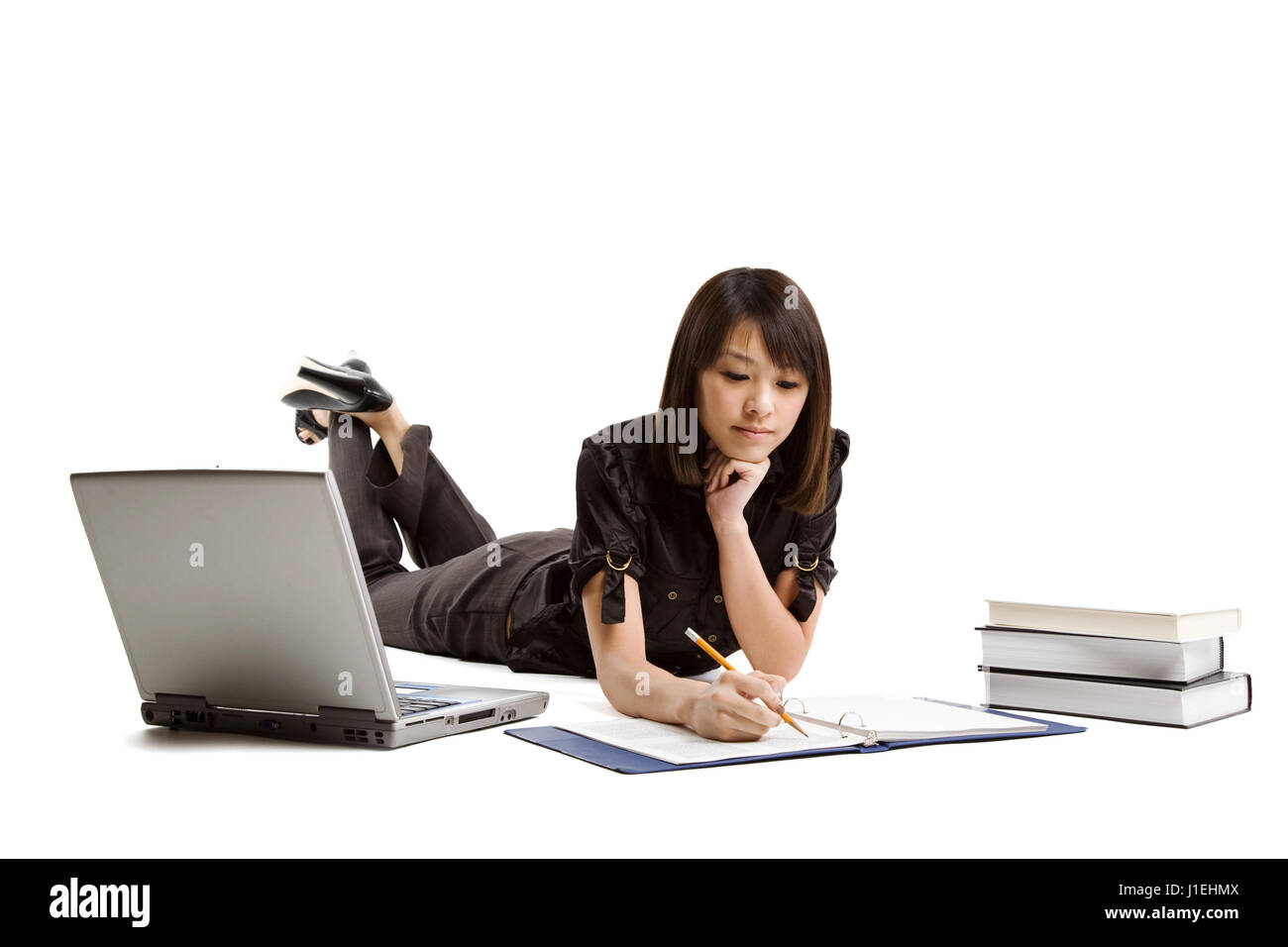 An isolated shot of a beautiful student studying with laptop and books ...