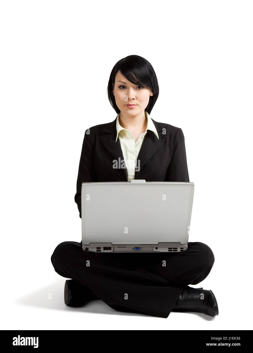 A businesswoman sitting on the floor working on her laptop Stock Photo ...