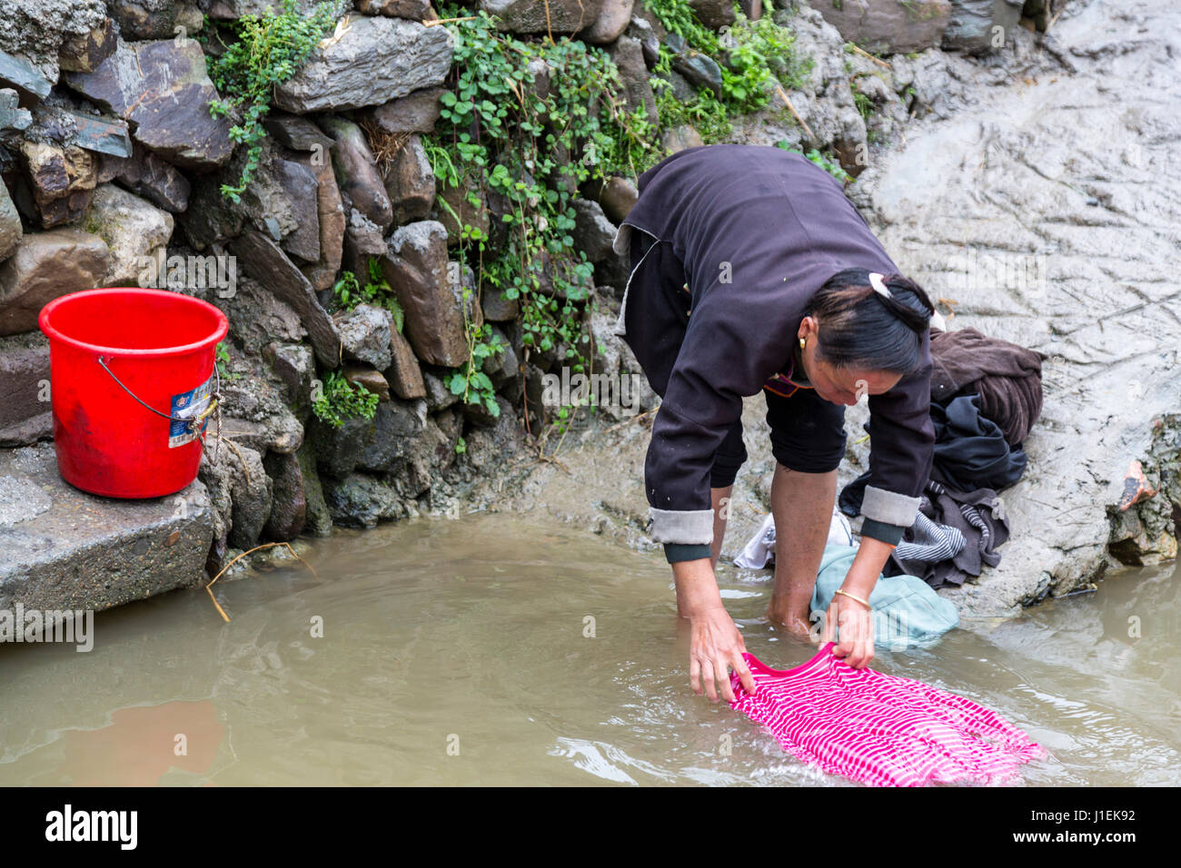 Huanggang, Guizhou, China. A Dong Ethnic Village. Woman Washing Clothes ...