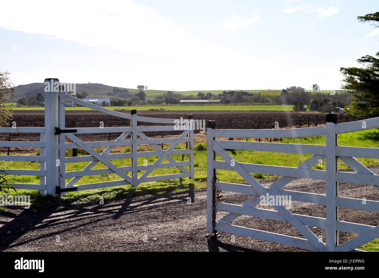 Farm entrance gate landscape background Stock Photo - Alamy