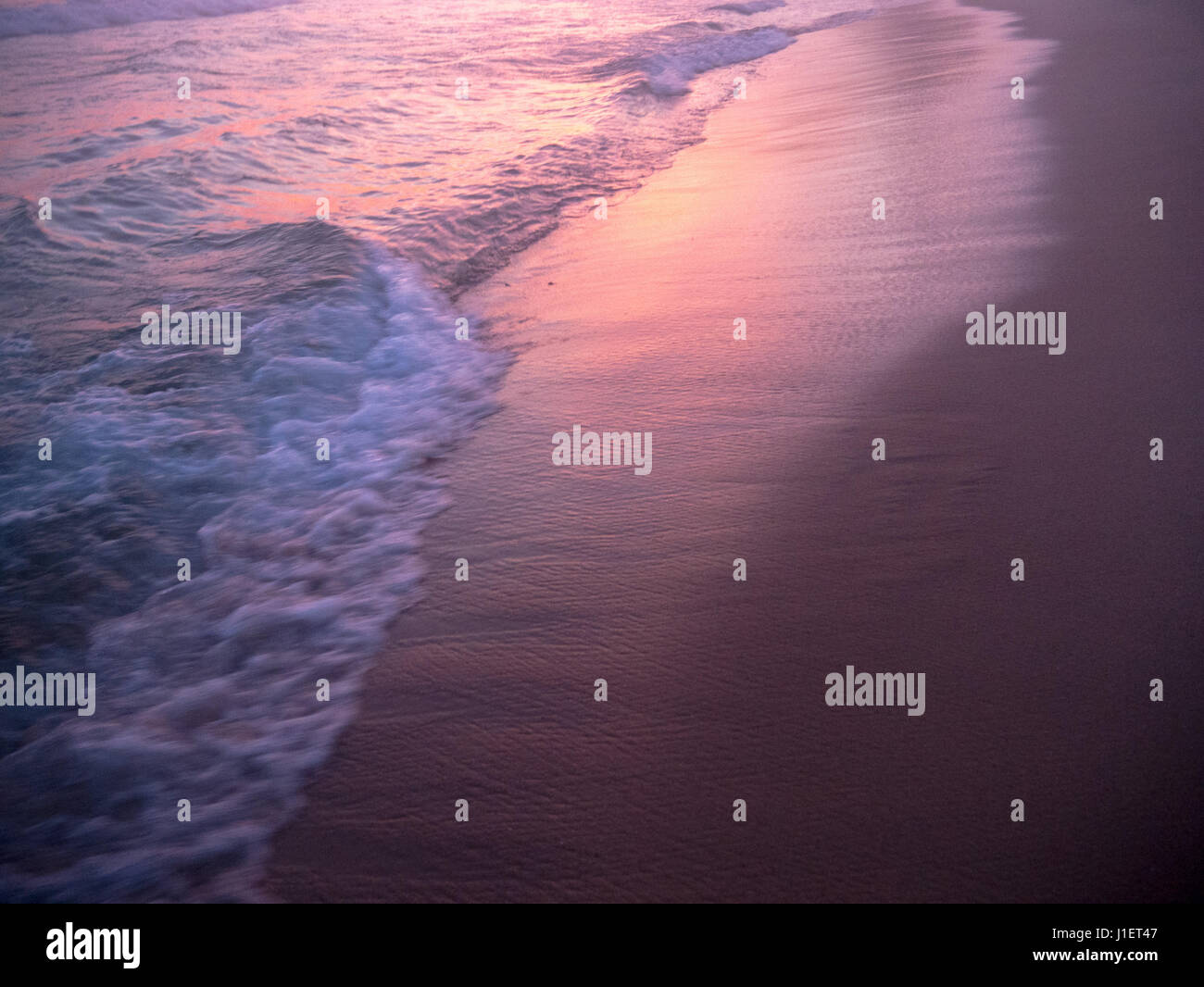 Sunset reflection on the beach Stock Photo - Alamy