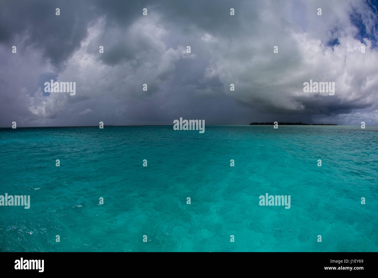 Rain clouds drift across an aqua-colored lagoon in the Republic of ...