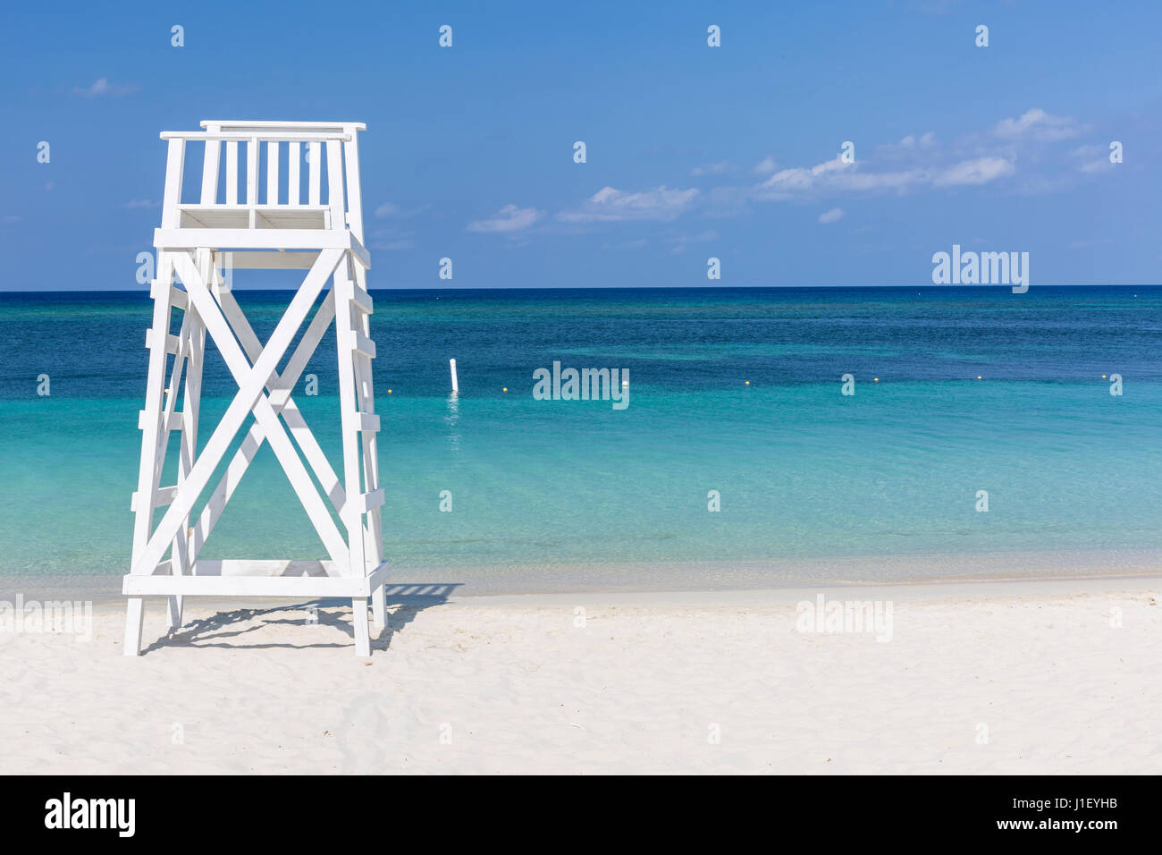 A white lifeguard tower near the tranquil waters off West Bay Beach in ...