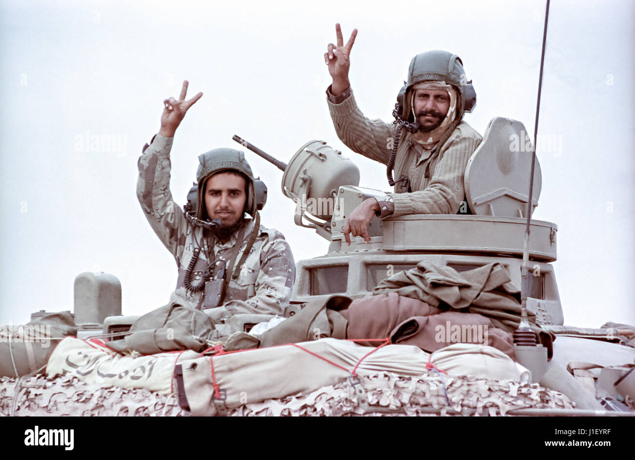 Qatari tank soldiers hold their hands up in the victory sign after ...