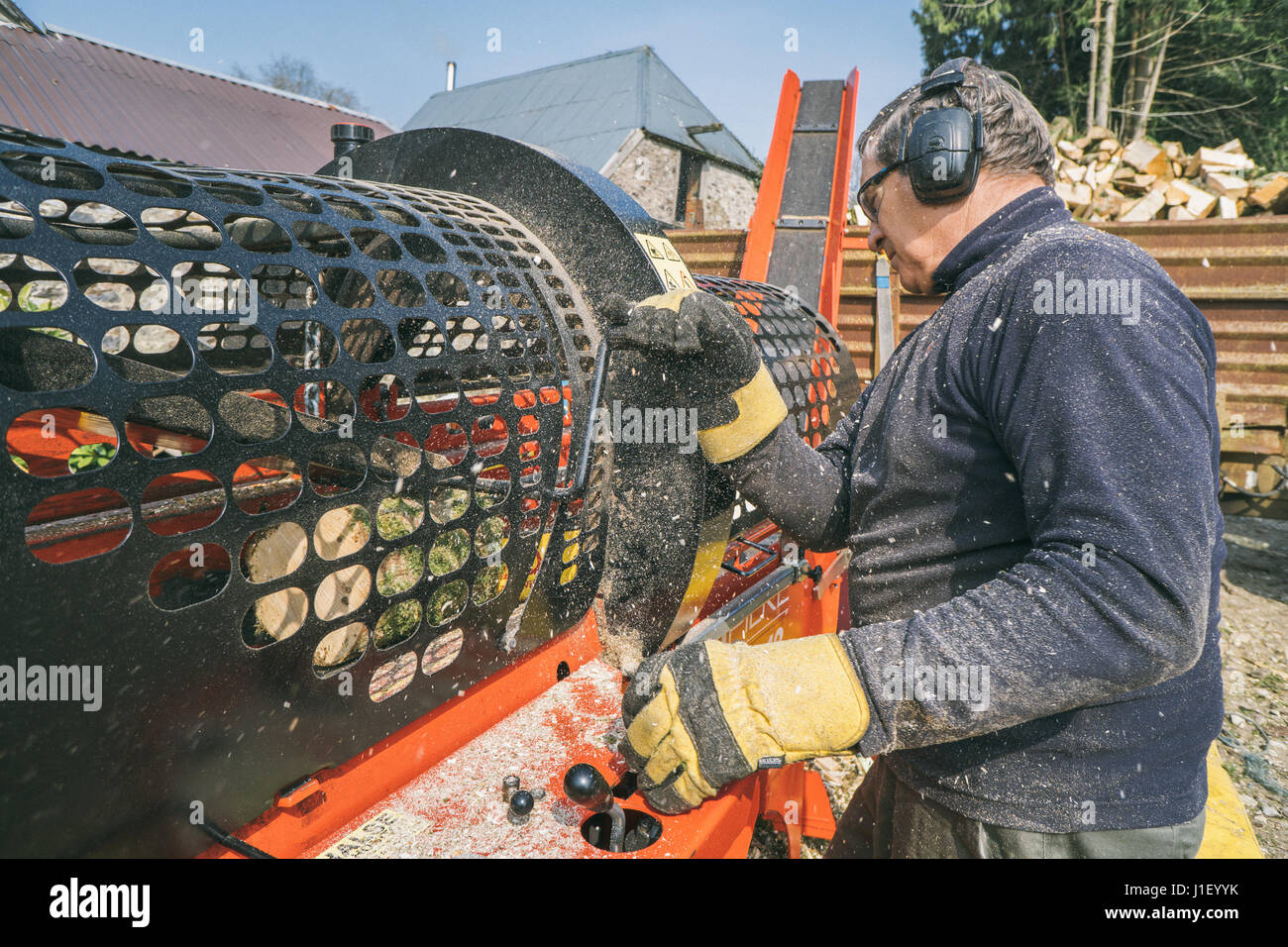 Man processing wood with logging machine Stock Photo - Alamy