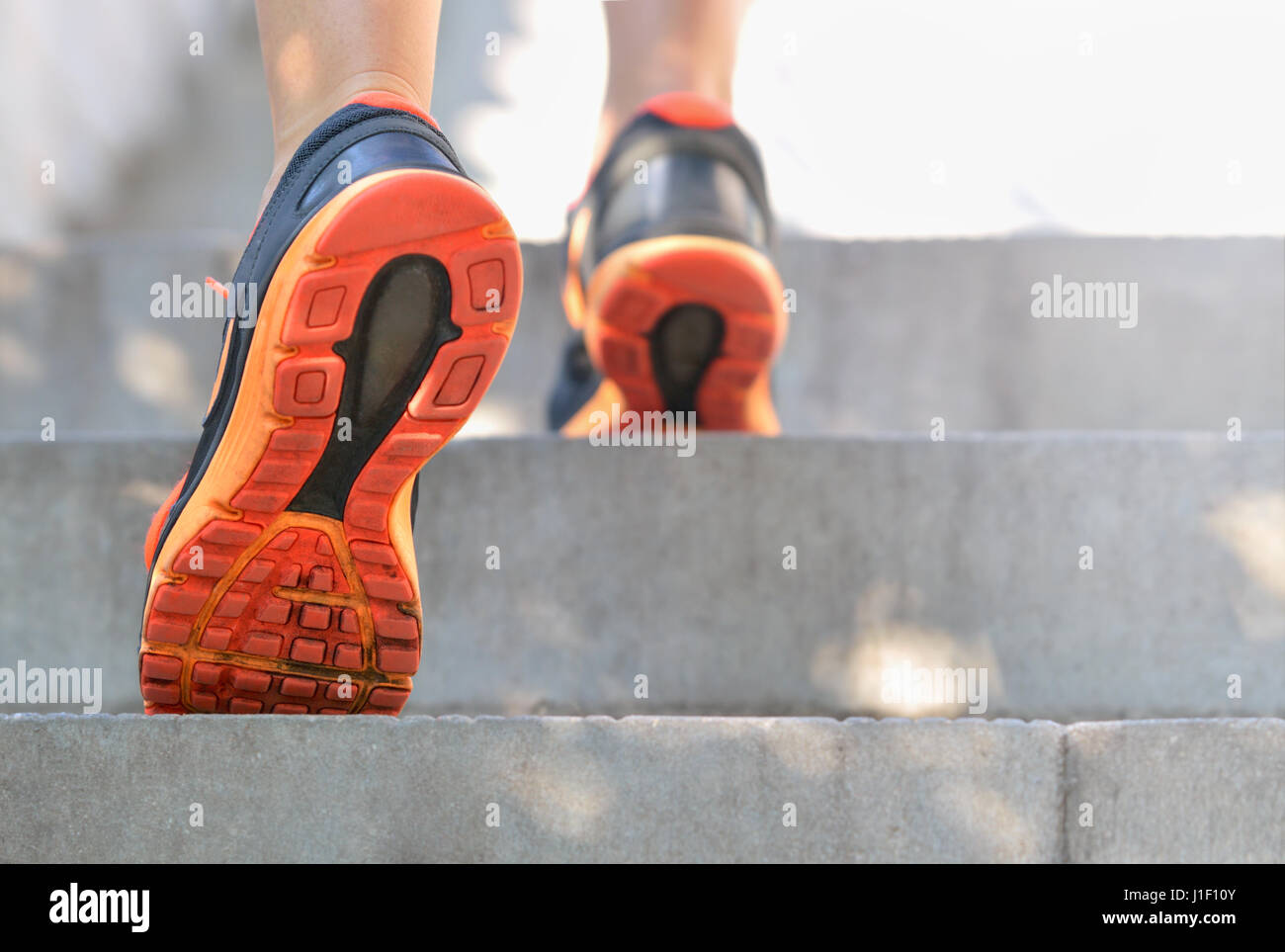 Low angle rear portrait of female runner in action on staircase Stock ...