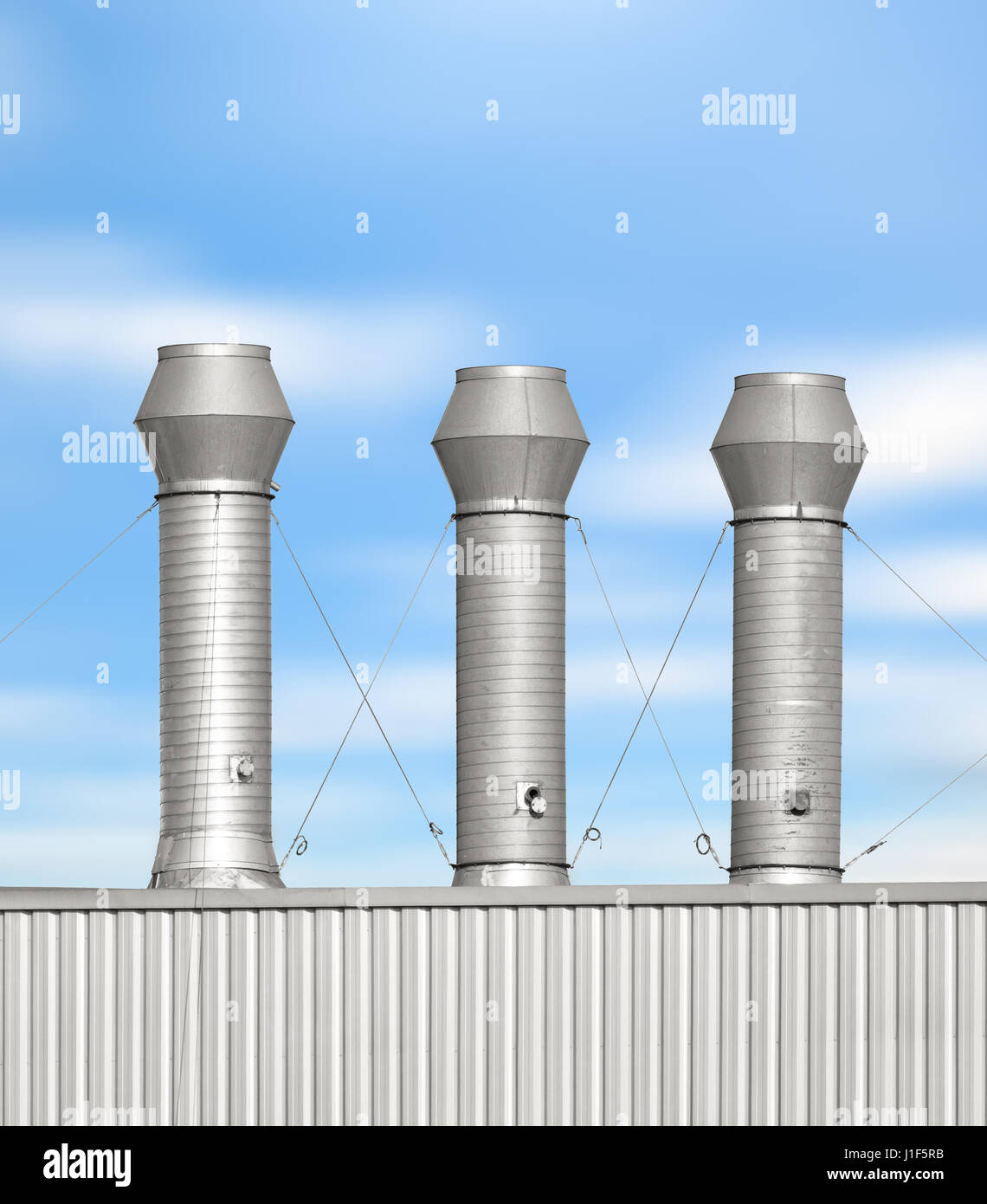 Air duct or steel pipe on roof of factory building with blue sky ...