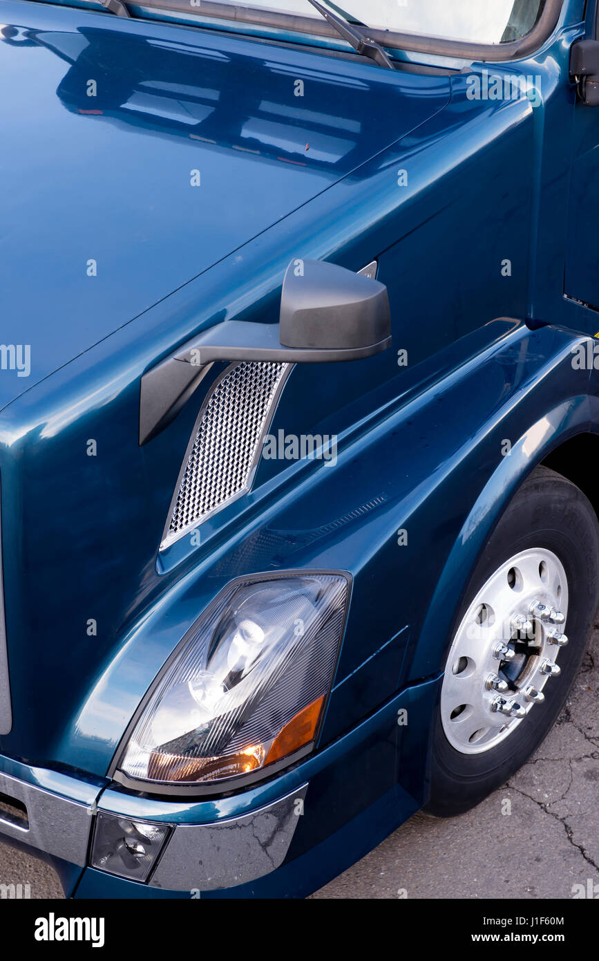 Fragment of side of dark blue big rig semi truck with modern shapes of ...