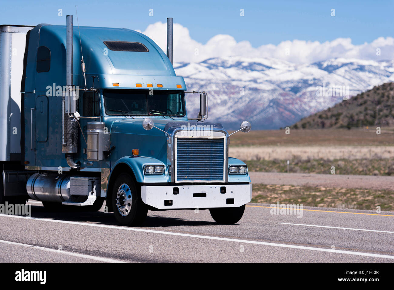 Classic big rig blue semi truck with trailer and tall exhaust pipes ...