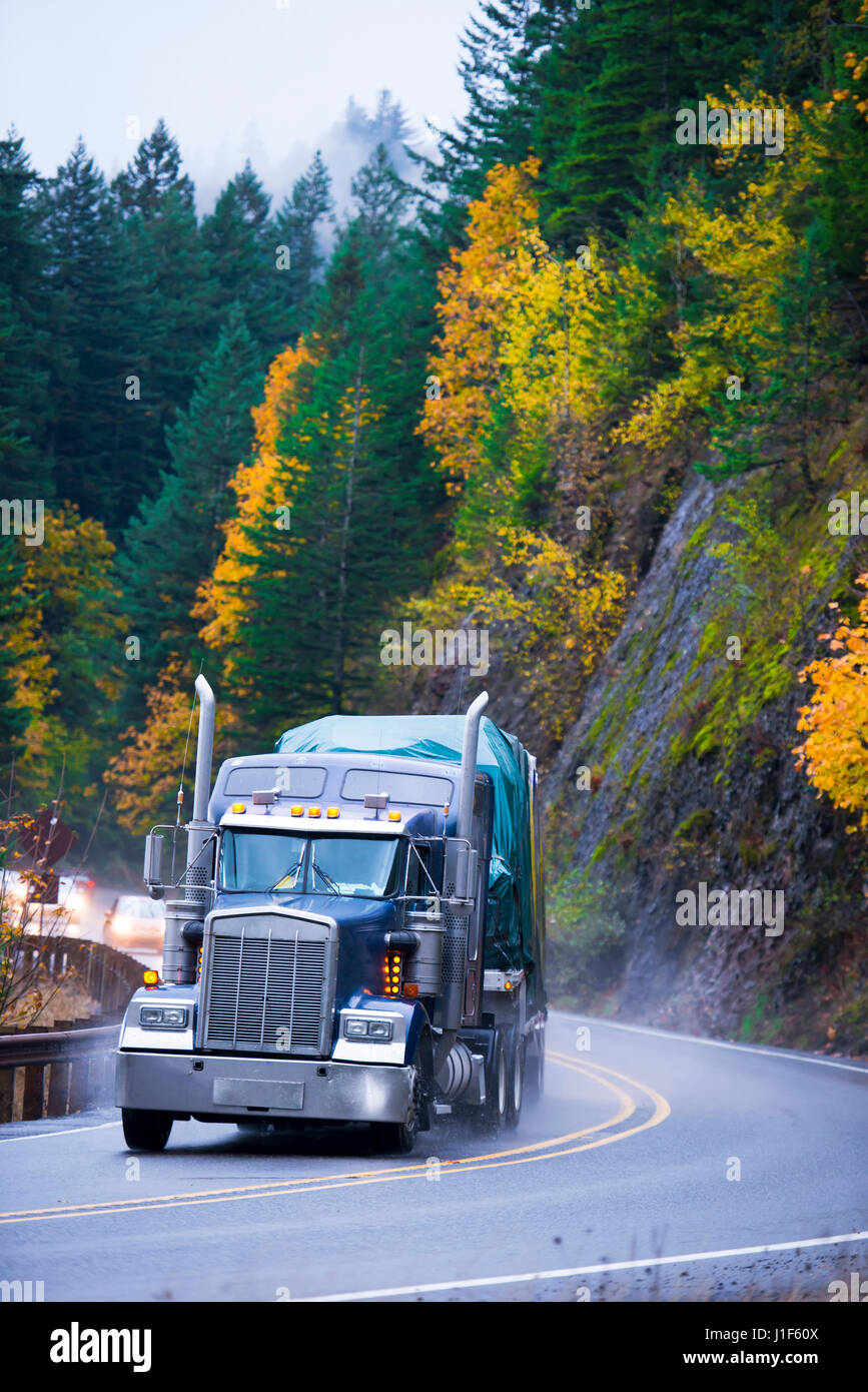 Powerful dark blue semi truck with high chrome tailpipes with a cargo ...