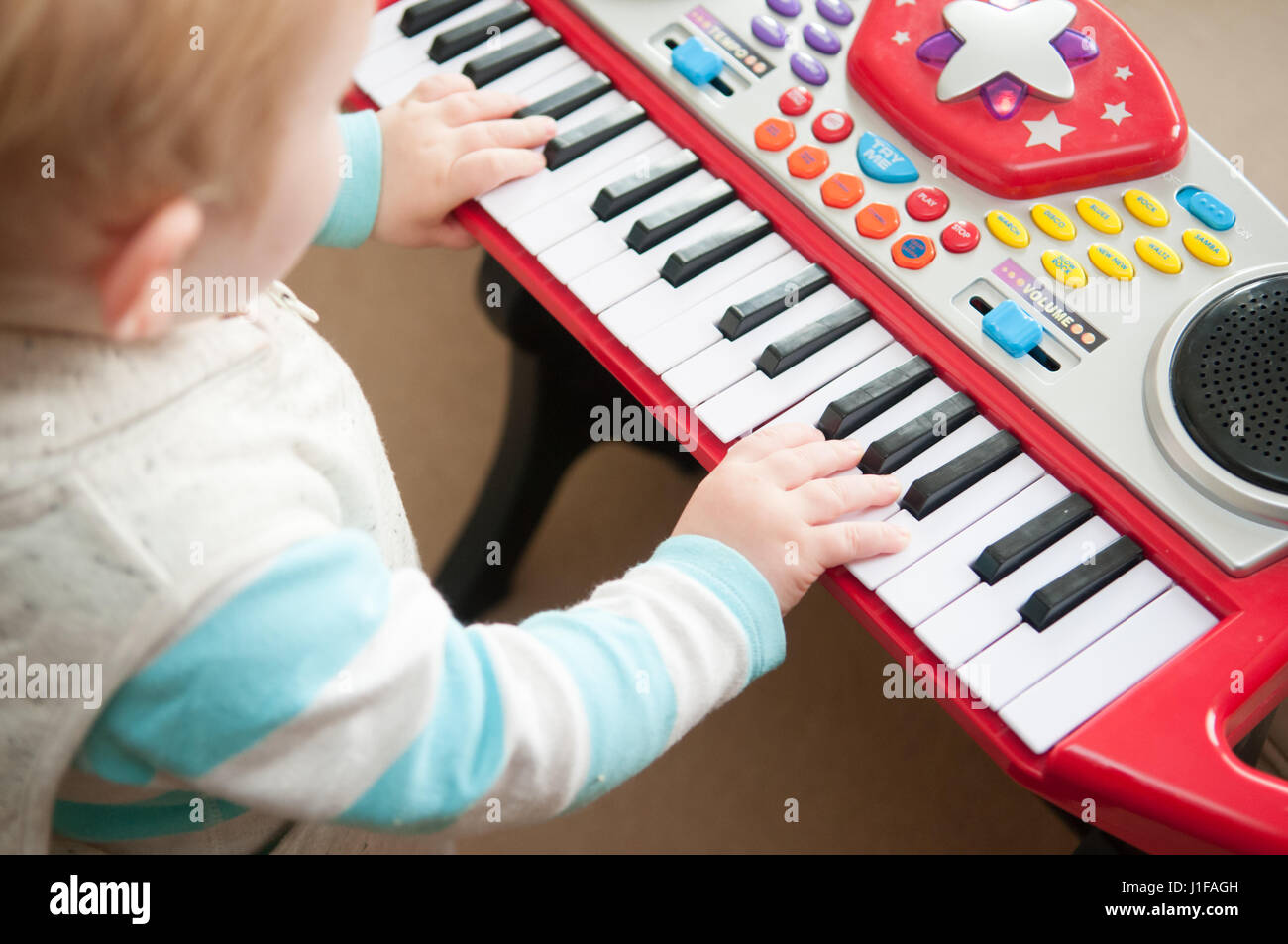 Young boy playing with a musical instrument toy at home Stock Photo - Alamy