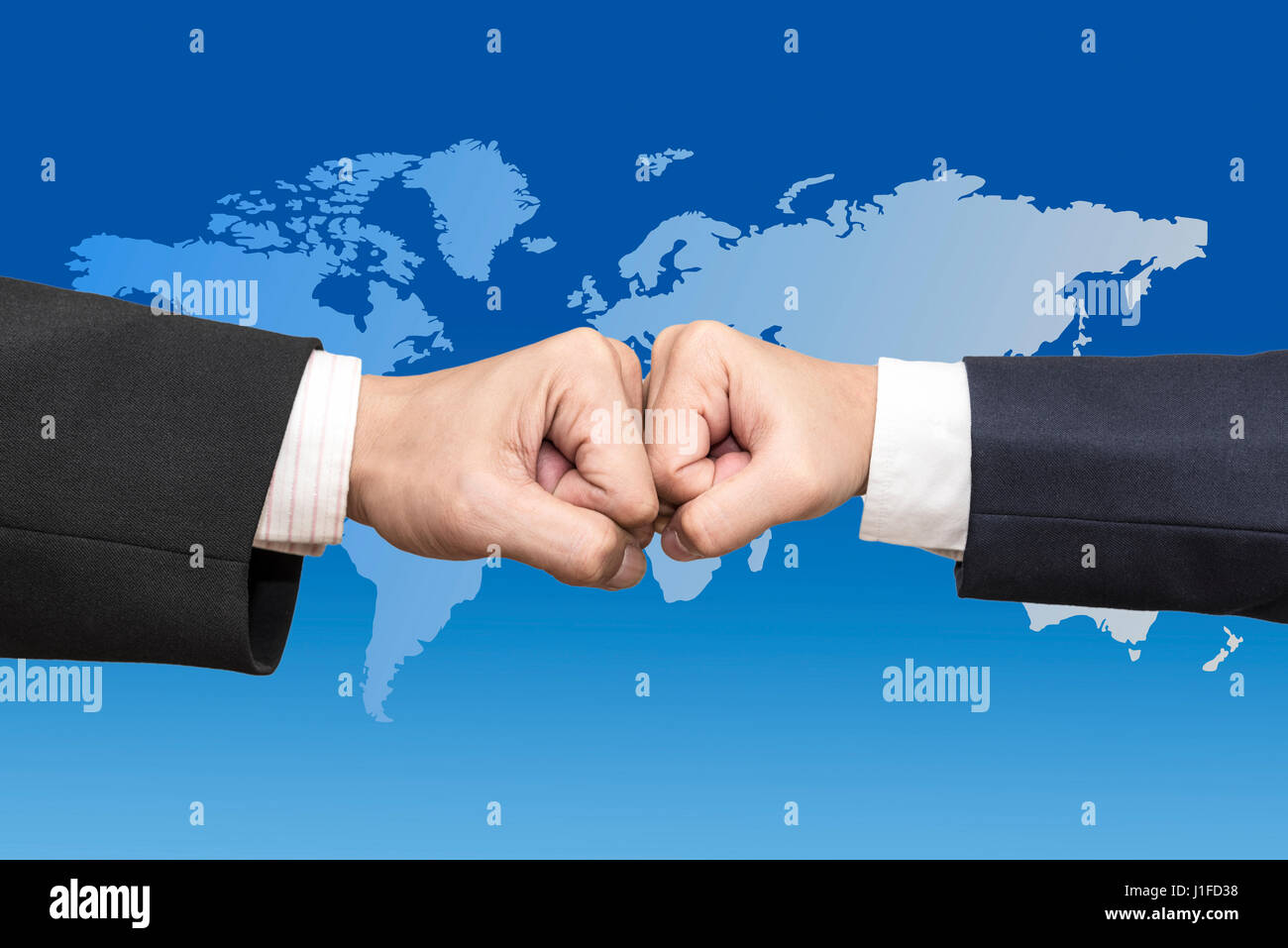 Two businessmen punch hands each other over globe map background ...