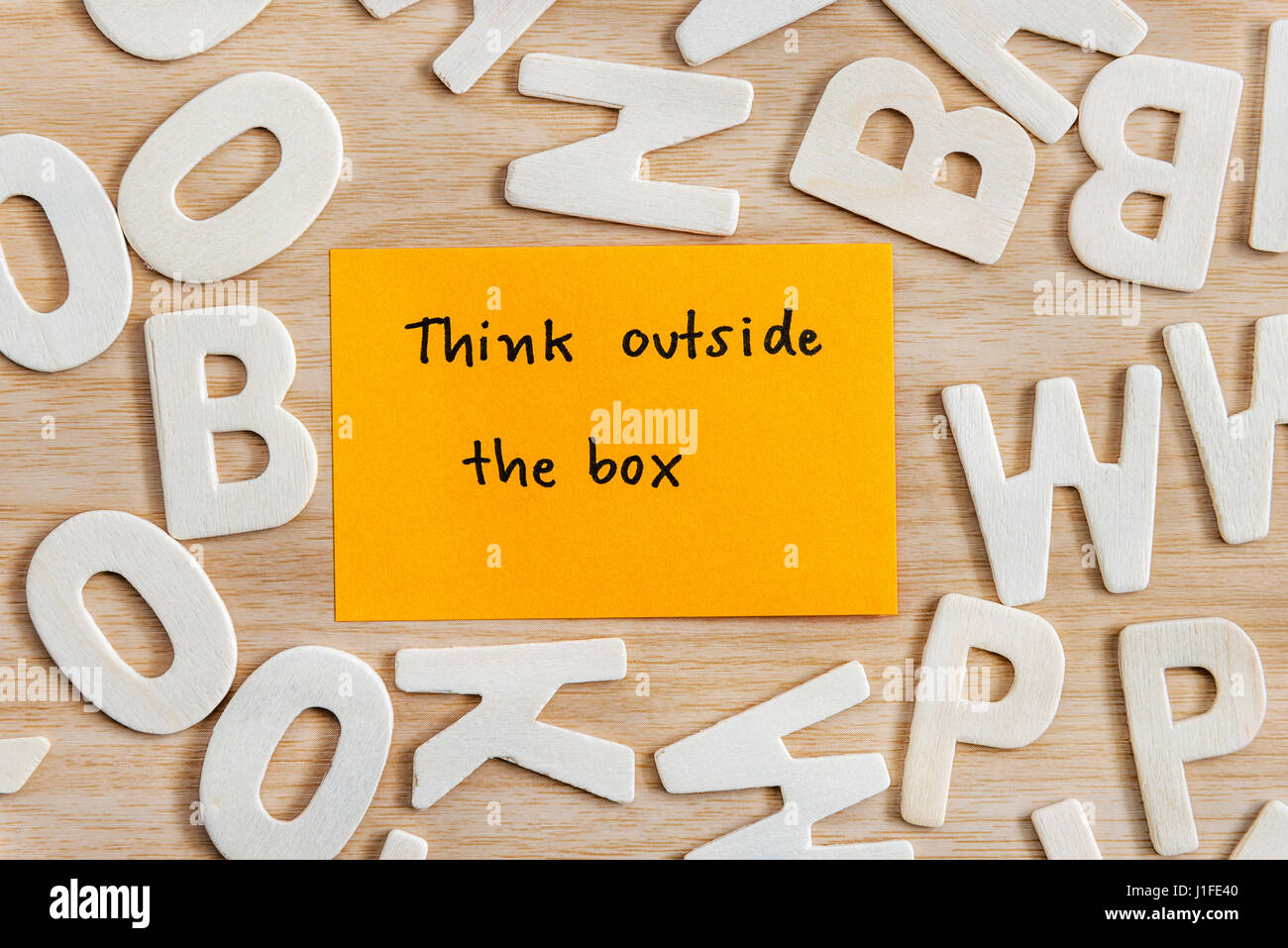 Handwriting letters words think outside the box on yellow sticky note ...