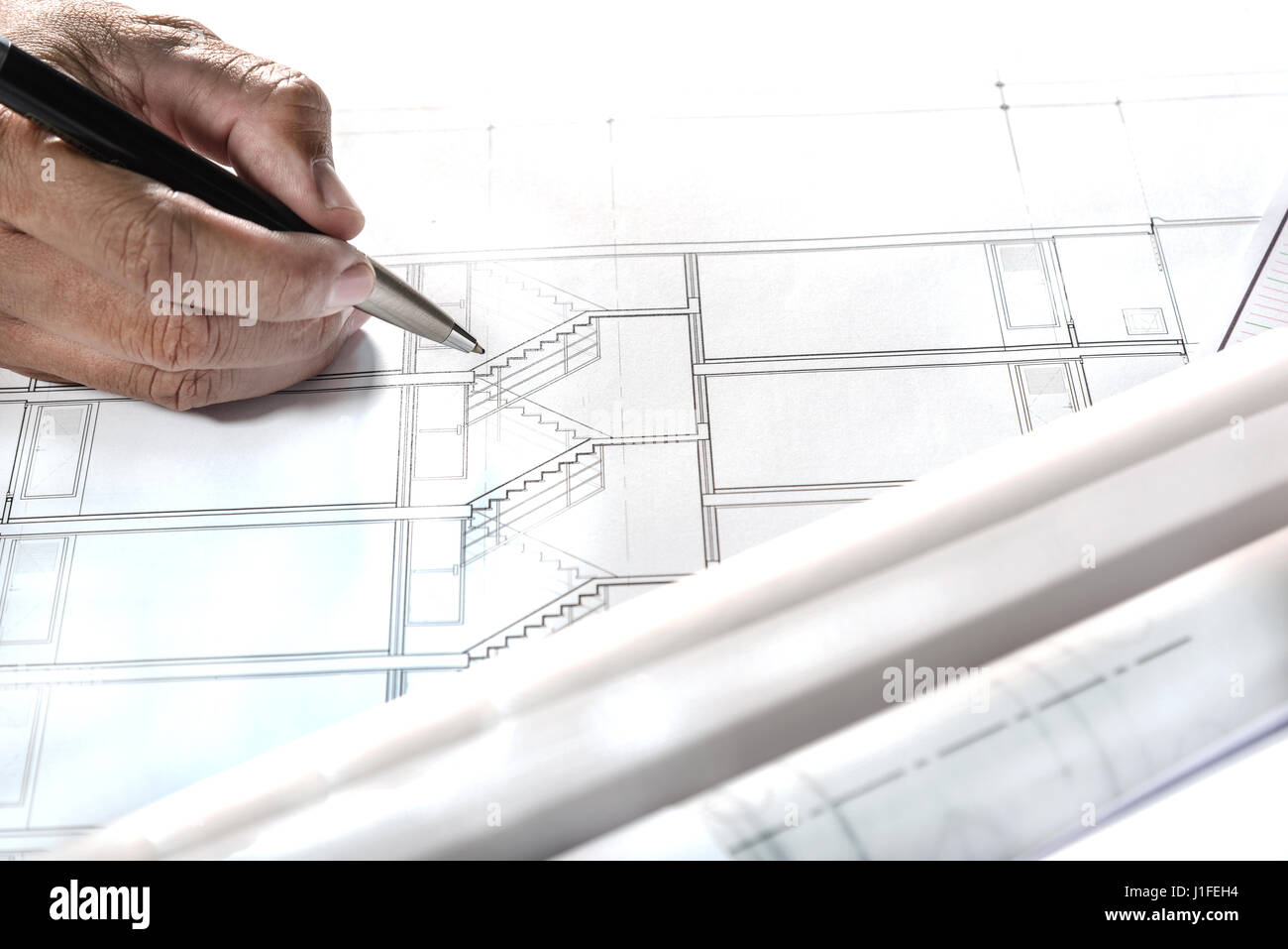 engineer hand holding pen point to architectural plans project drawing ...
