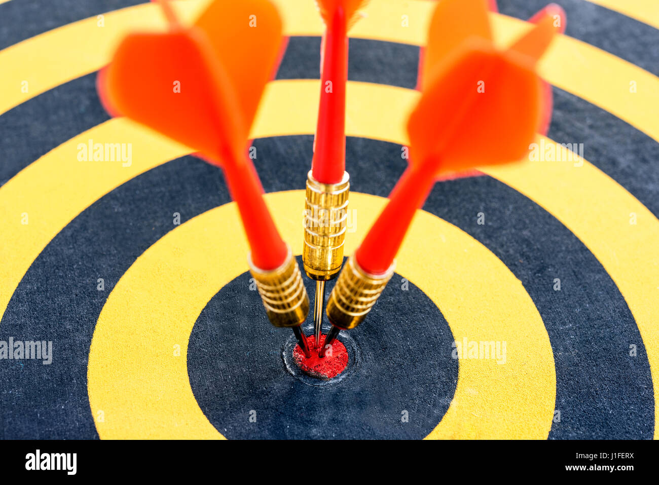 closeup one target with three dart arrows hitting the bullseye (center ...