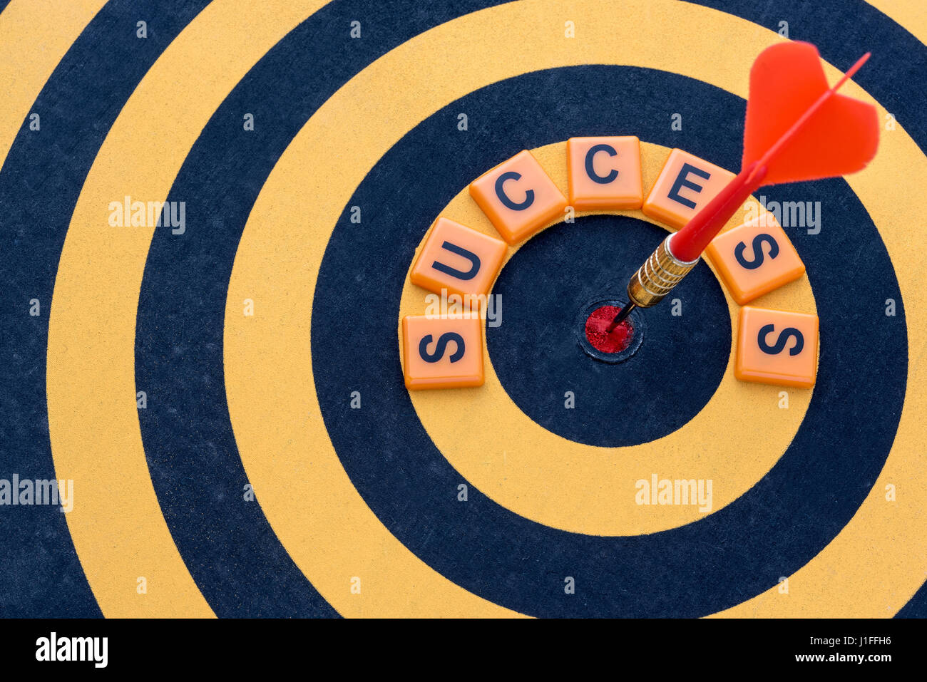 Dart hitting the bullseye target with word success on dartboard ...