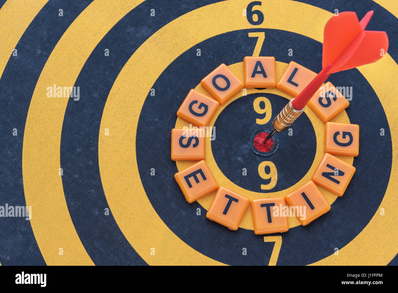 Words goals setting and dart target arrow on the bullseye of dartboard ...