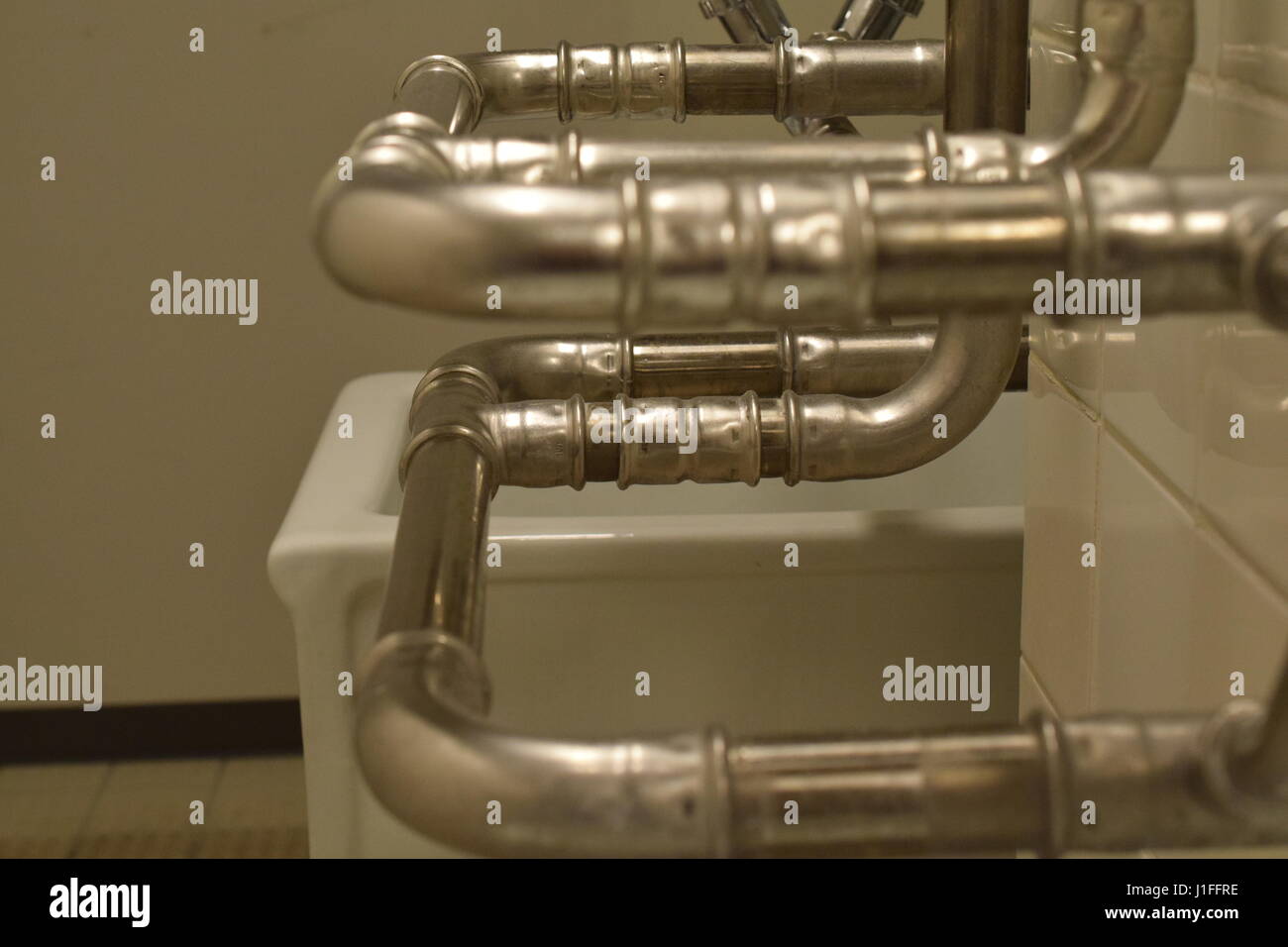 Metal pipes and faucet in changing room Stock Photo - Alamy