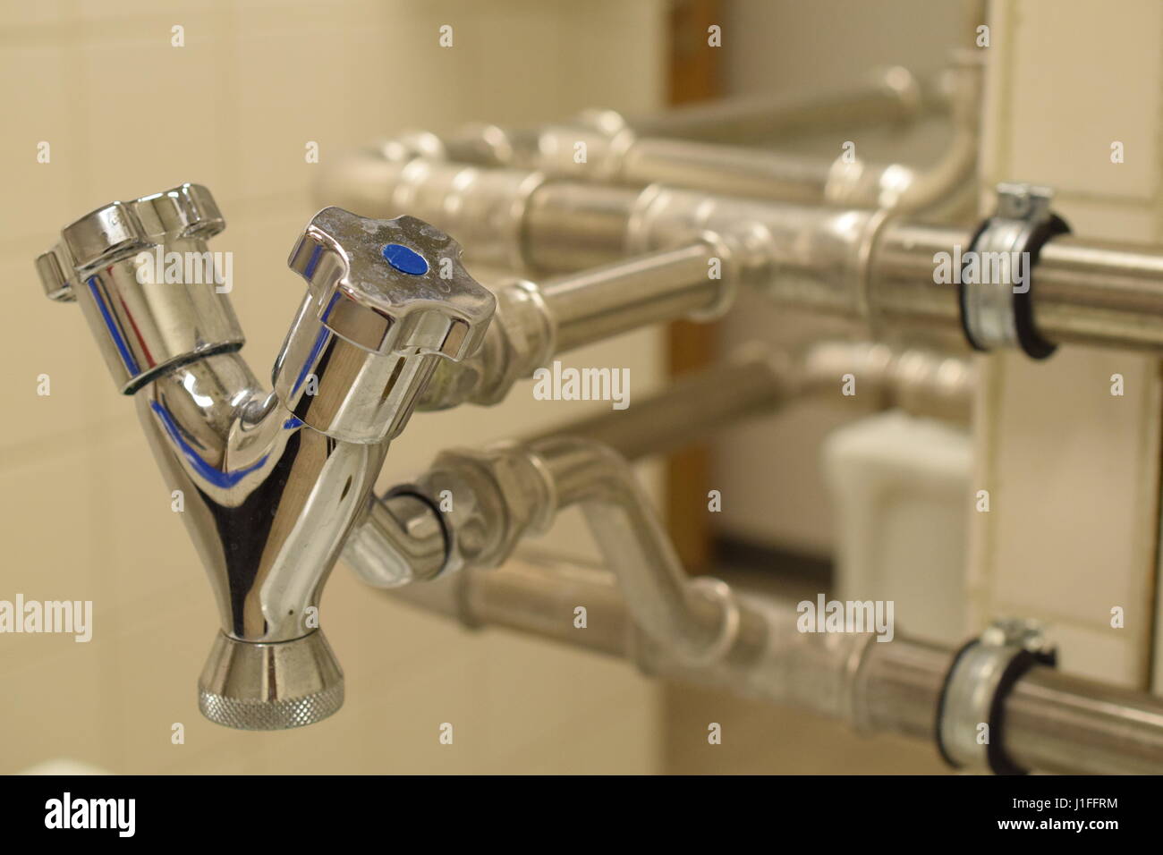 Metal pipes and faucet in changing room Stock Photo - Alamy