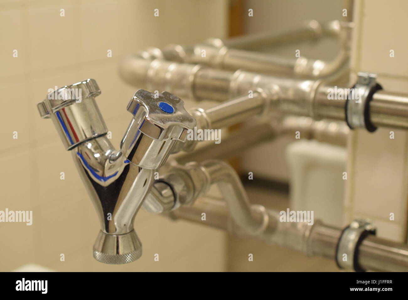 Metal pipes and faucet in changing room Stock Photo - Alamy