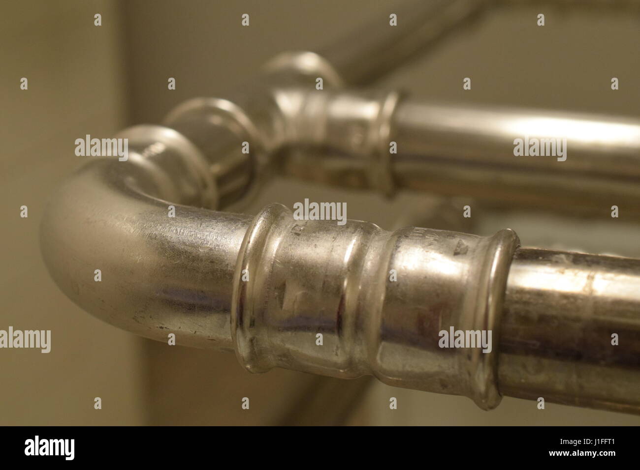 Metal pipes and faucet in changing room Stock Photo - Alamy