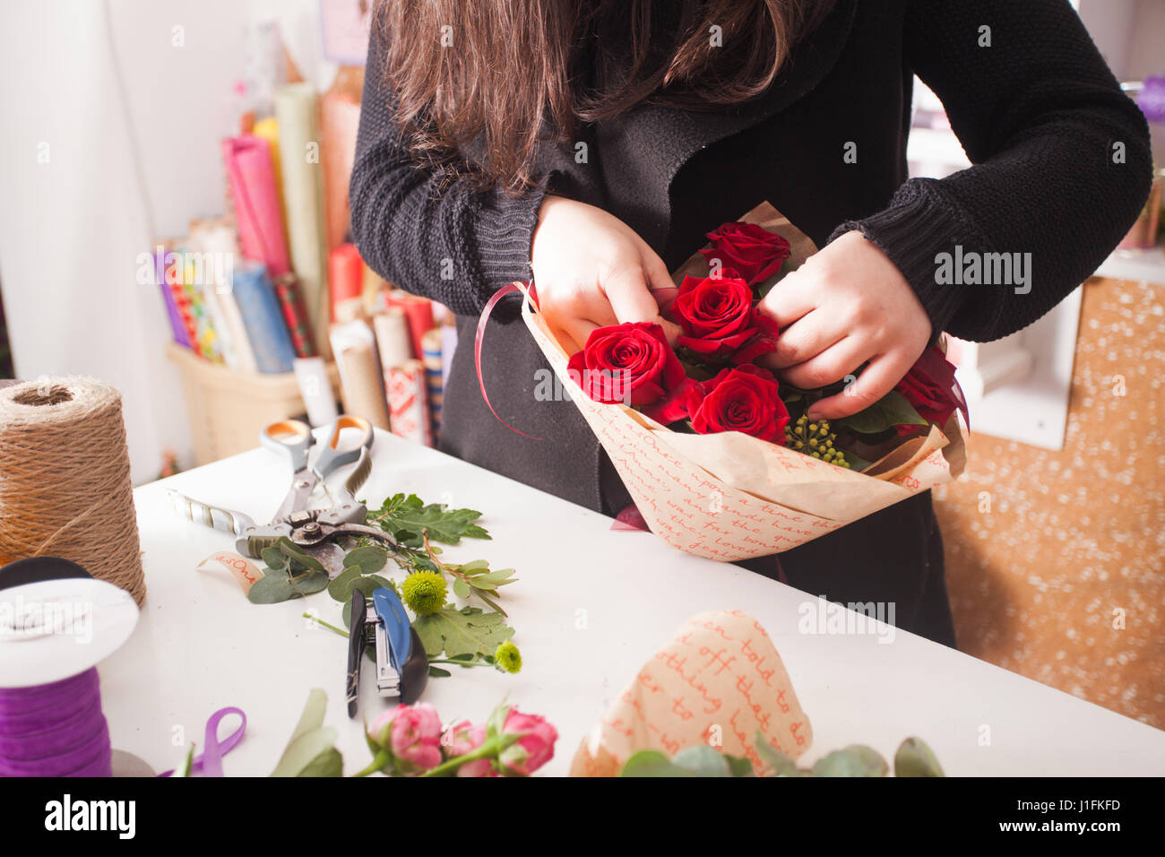 Florist making bouquet of red roses Stock Photo - Alamy