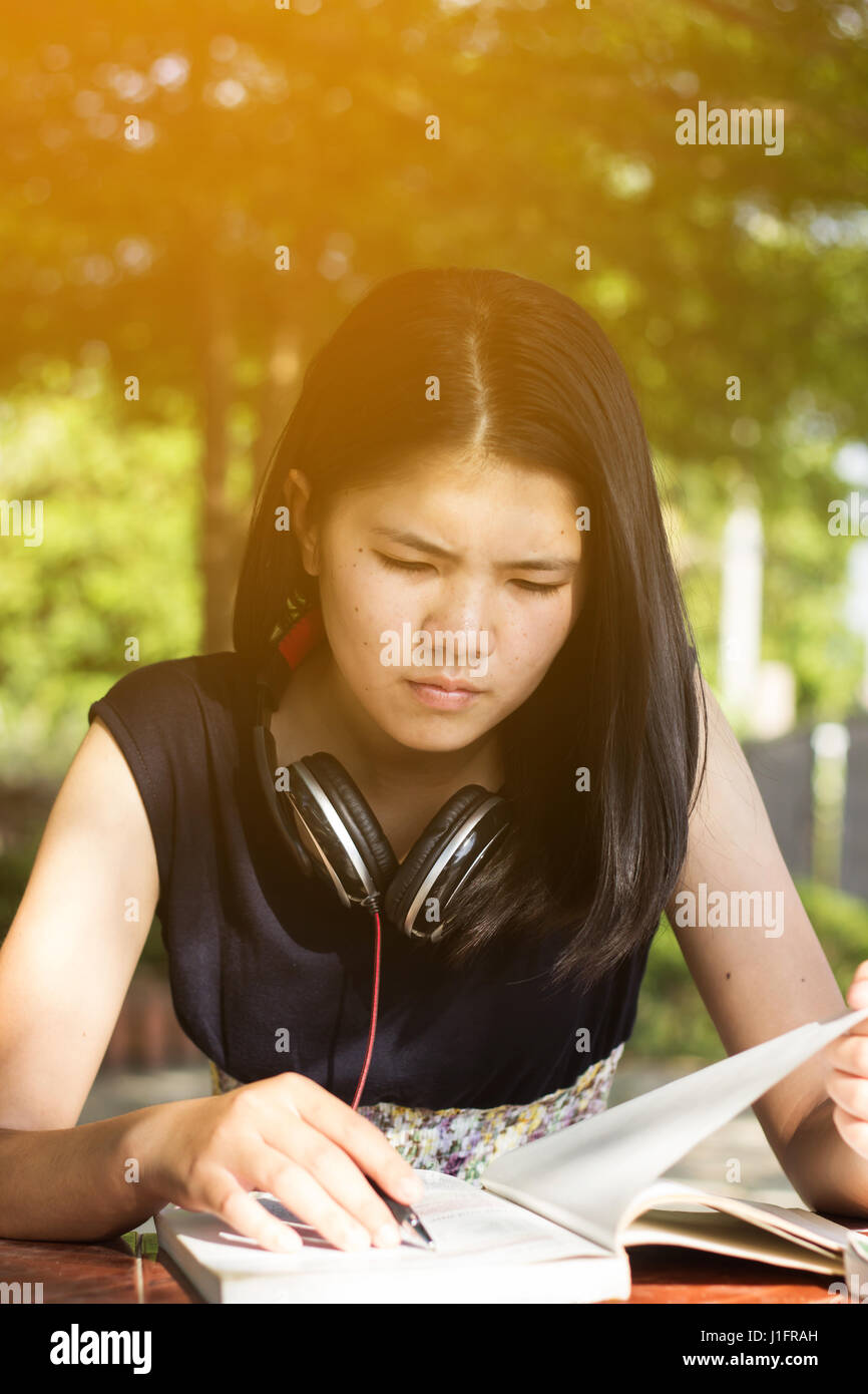 Asian teen student reading book preparing for exam Stock Photo - Alamy