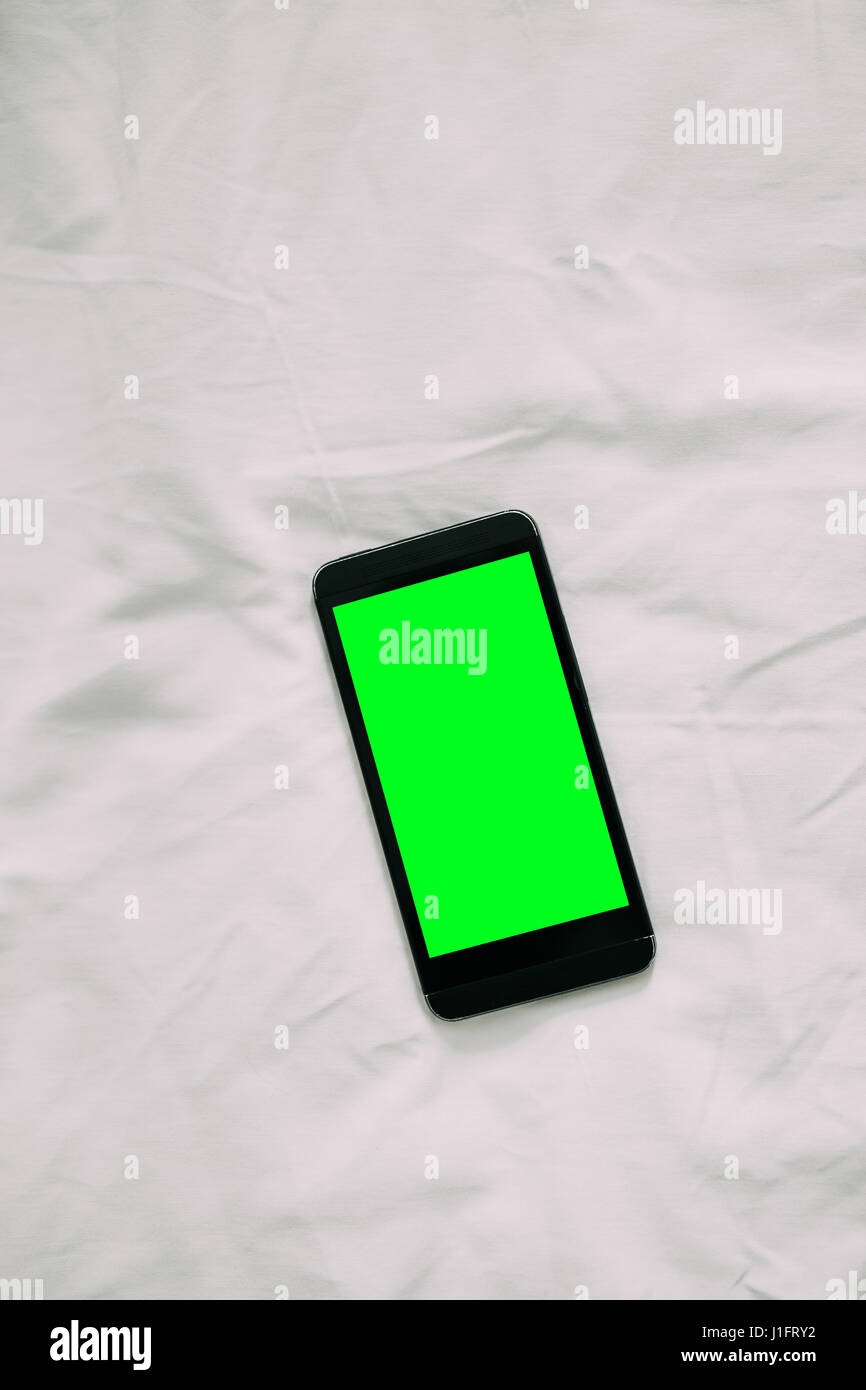 Closeup aerial view of white smart phone with green isolated screen on ...