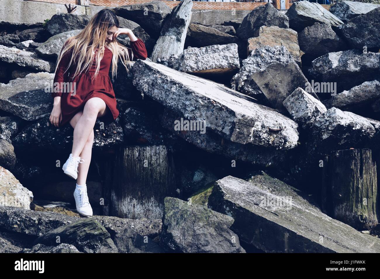 Girl sitting on Rocks on the shores of Bellingham, Washington Stock ...