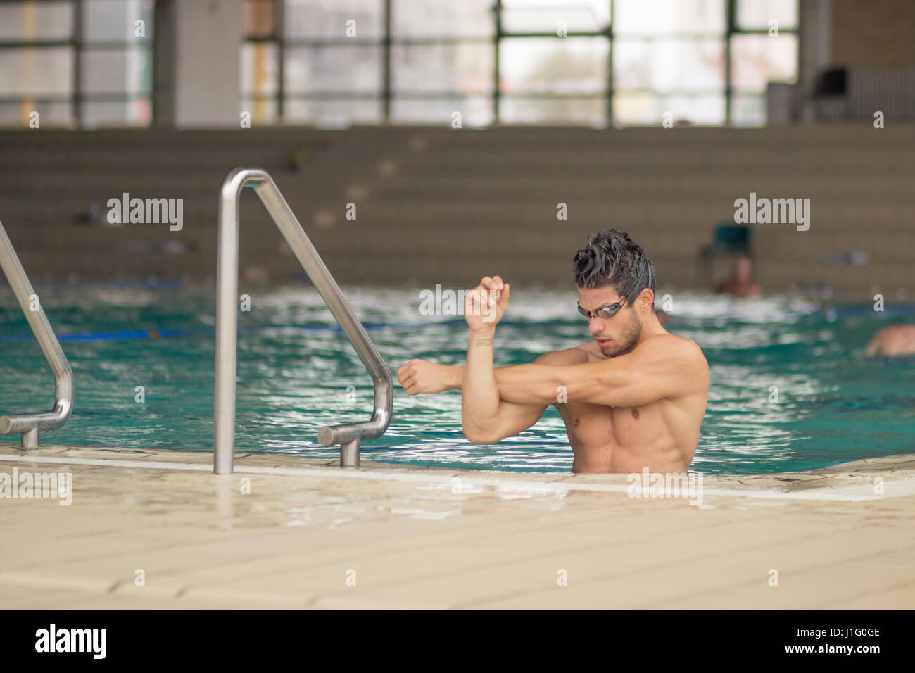 swimmer in pool water, stretching arms, indoors Stock Photo - Alamy