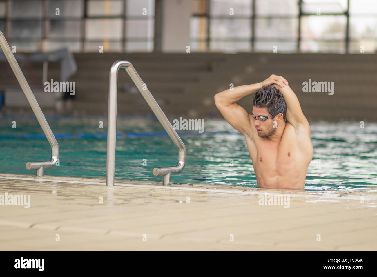 swimmer in pool water, stretching arms, indoors Stock Photo - Alamy