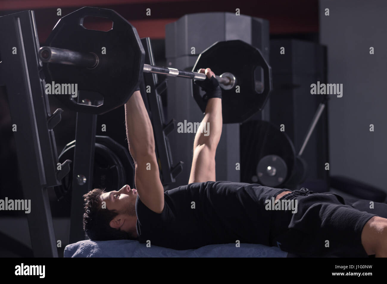young man lying laying, utility bench weights bar exercise fitness ...
