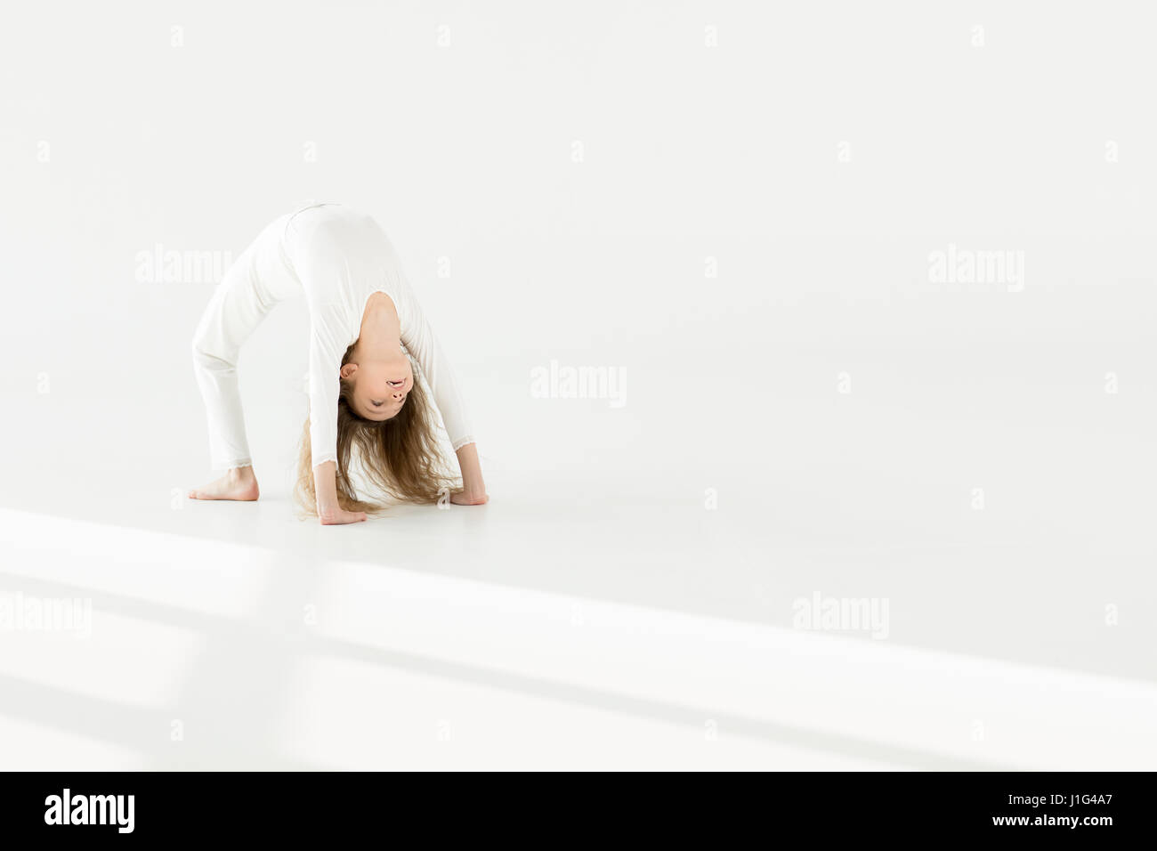 Cute preteen girl doing bridge exercise on white Stock Photo - Alamy