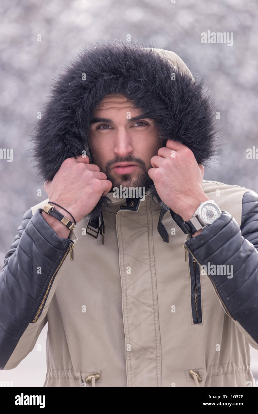 one young adult man cold winter outdoors head face. looking at camera ...