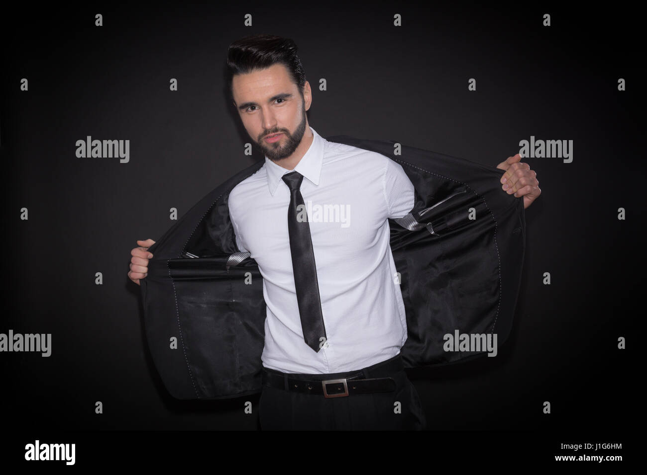 one young handsome man showing jacket suit, black background Stock ...