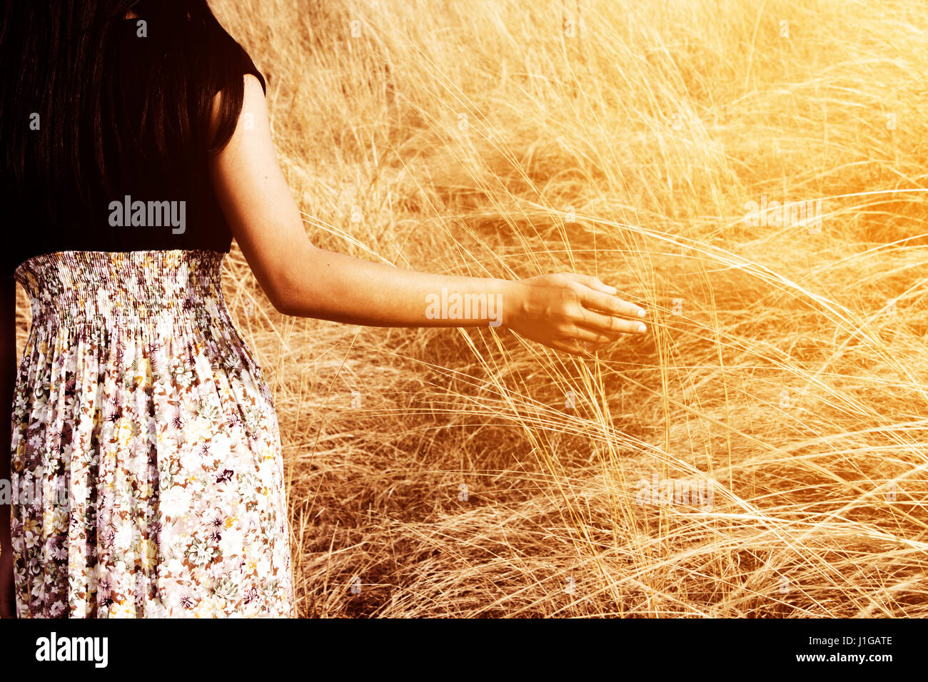 Girl walking in grass field Stock Photo - Alamy