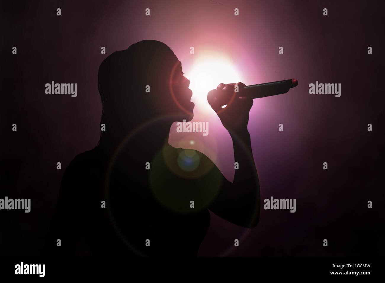 Women singing under spotlight Stock Photo - Alamy