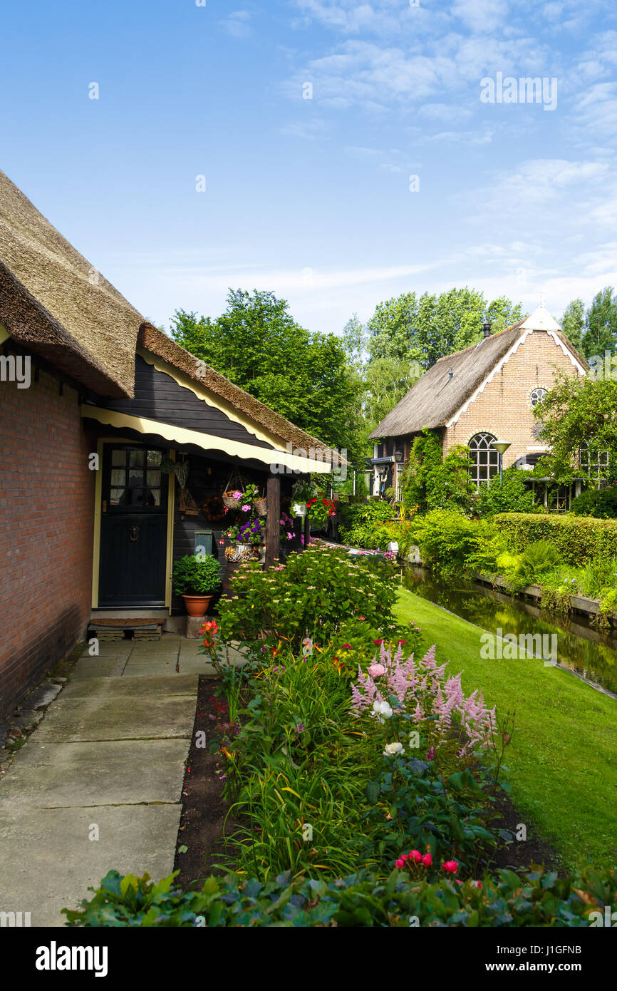 View of traditional village house in farm with trees and grass around ...