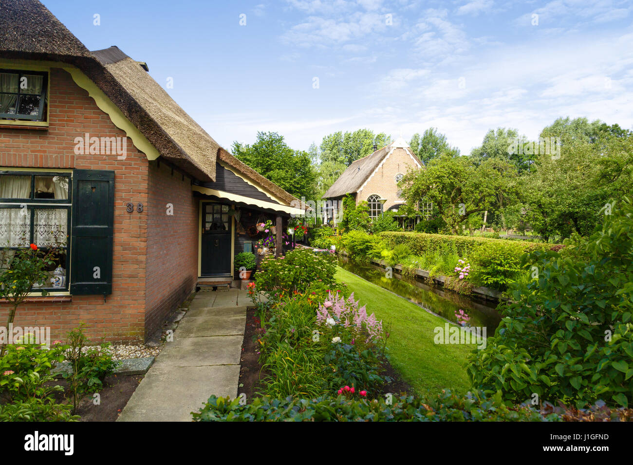 View of traditional village house in farm with trees and grass around ...