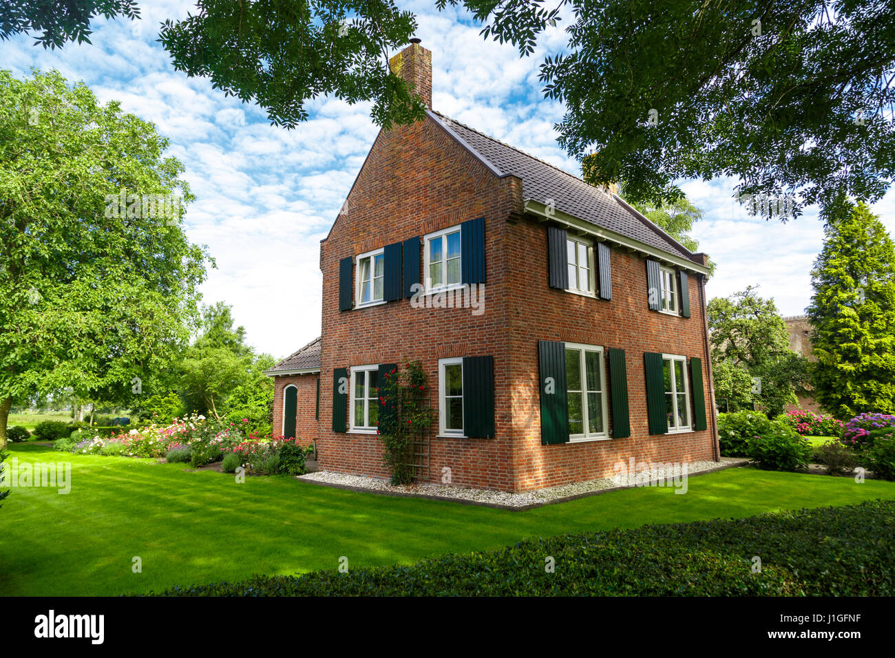 View of traditional village house in farm with trees and grass around ...