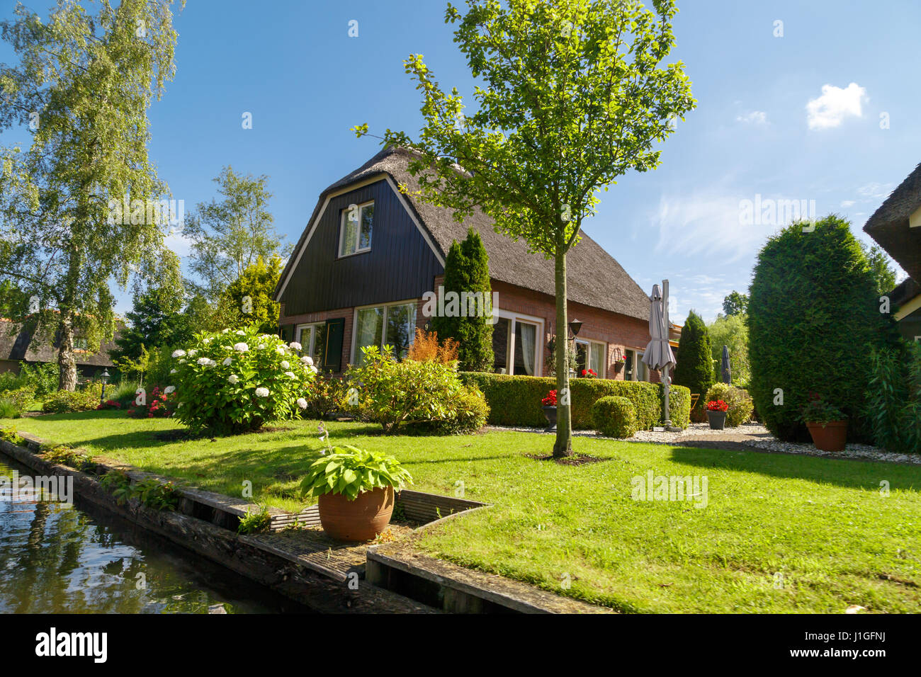 Landscape view of thatched rustic roof houses around canals in famous village Giethoorn Stock ...