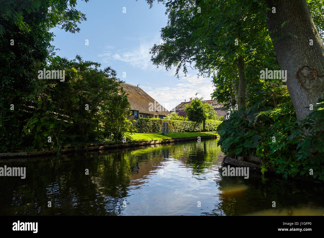 Landscape view of thatched rustic roof houses around canals in famous village Giethoorn Stock ...