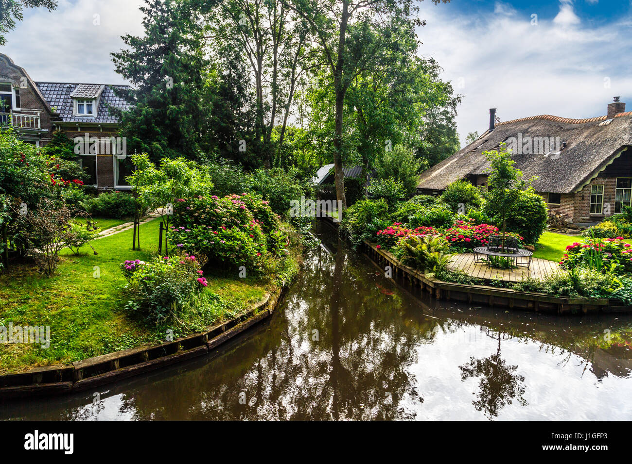 Landscape view of famous Giethoorn village with canals and rustic thatched roof houses in farm ...