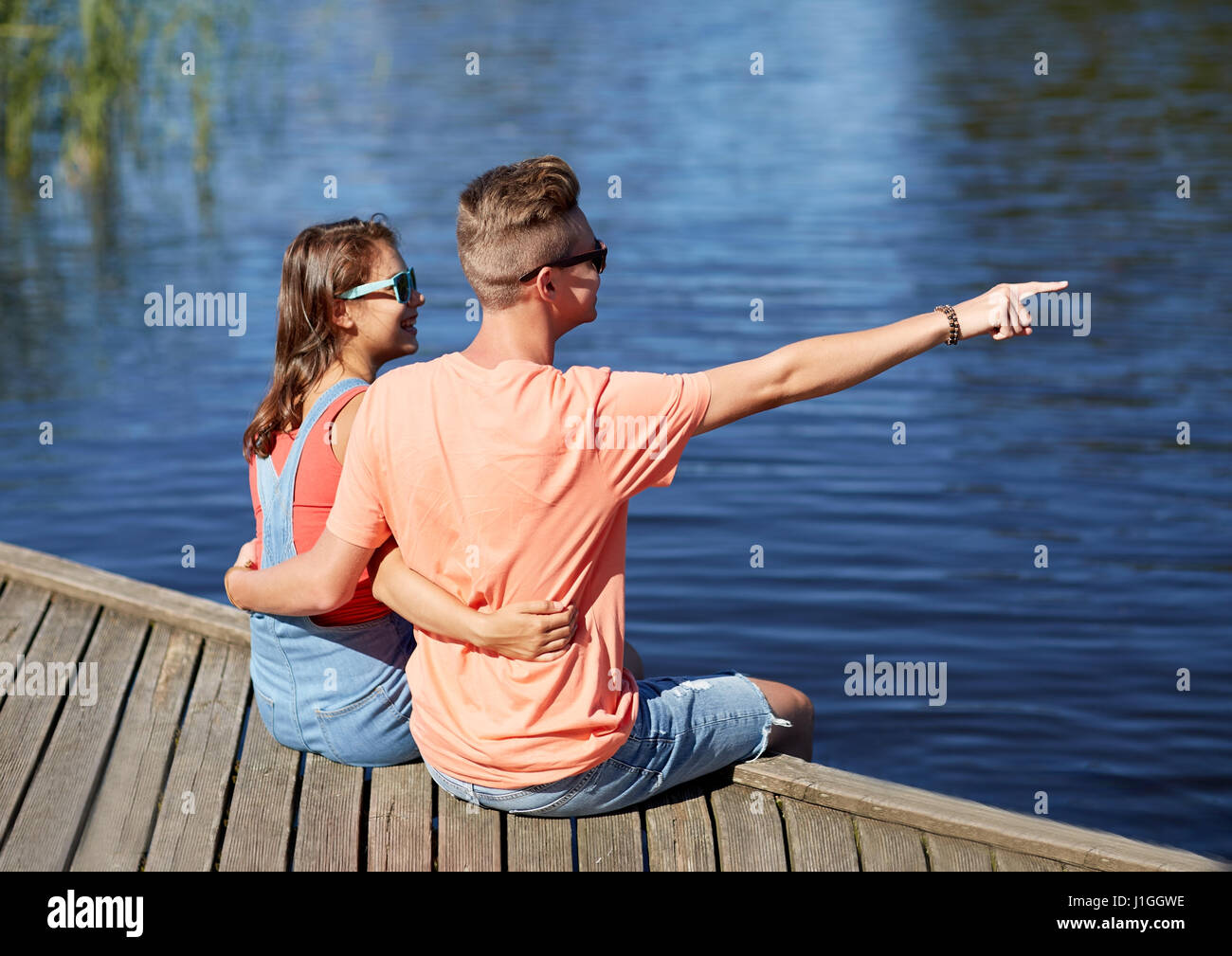 happy couple pointing finger on summer river berth Stock Photo - Alamy