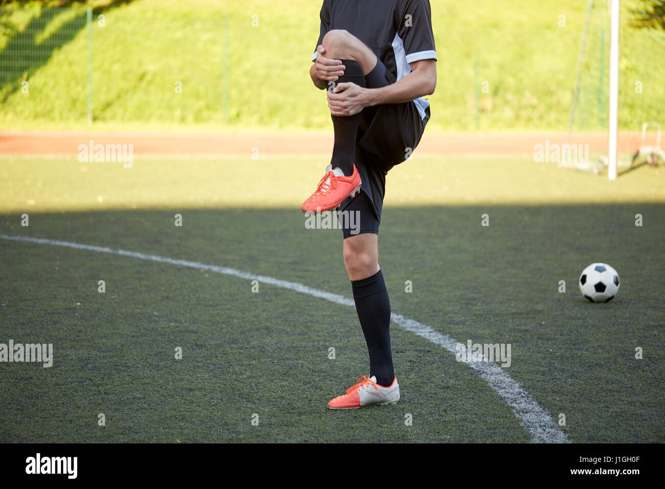 soccer player stretching leg on field football Stock Photo - Alamy