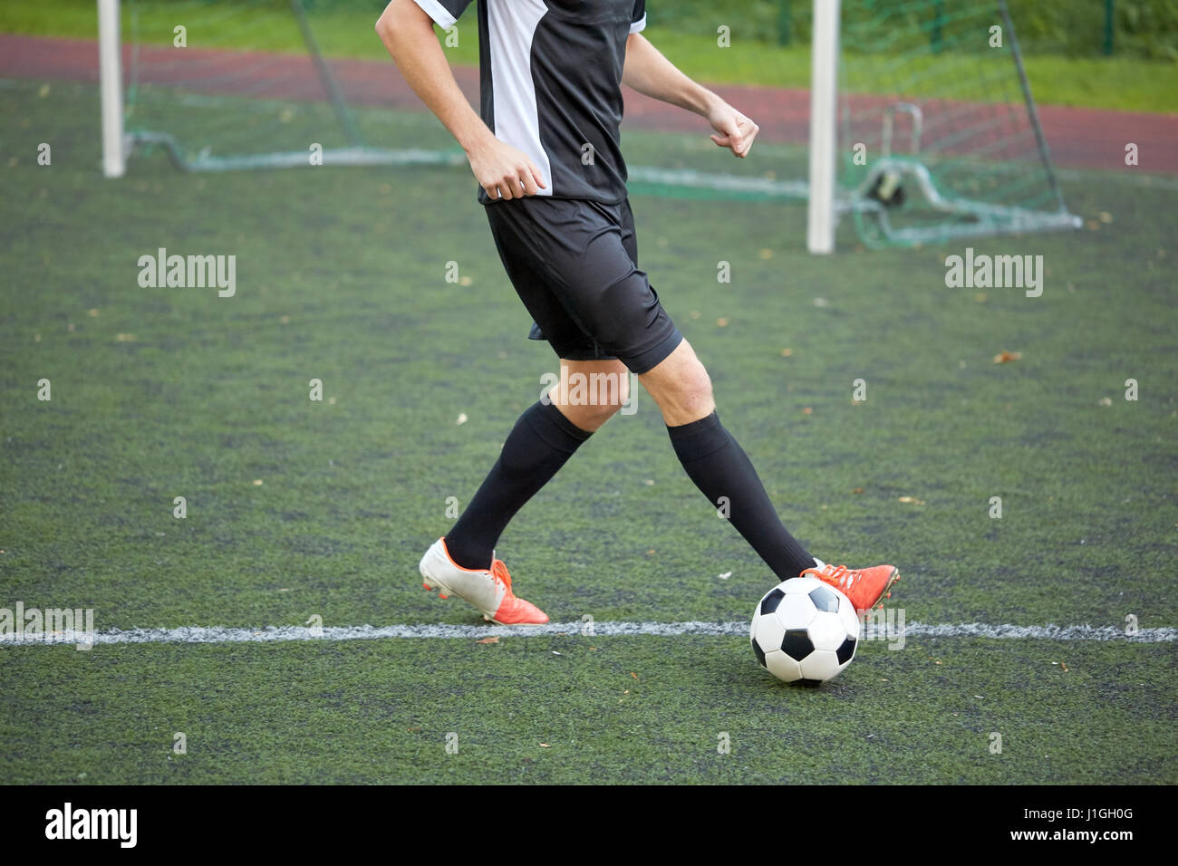 soccer player playing with ball on football field Stock Photo - Alamy