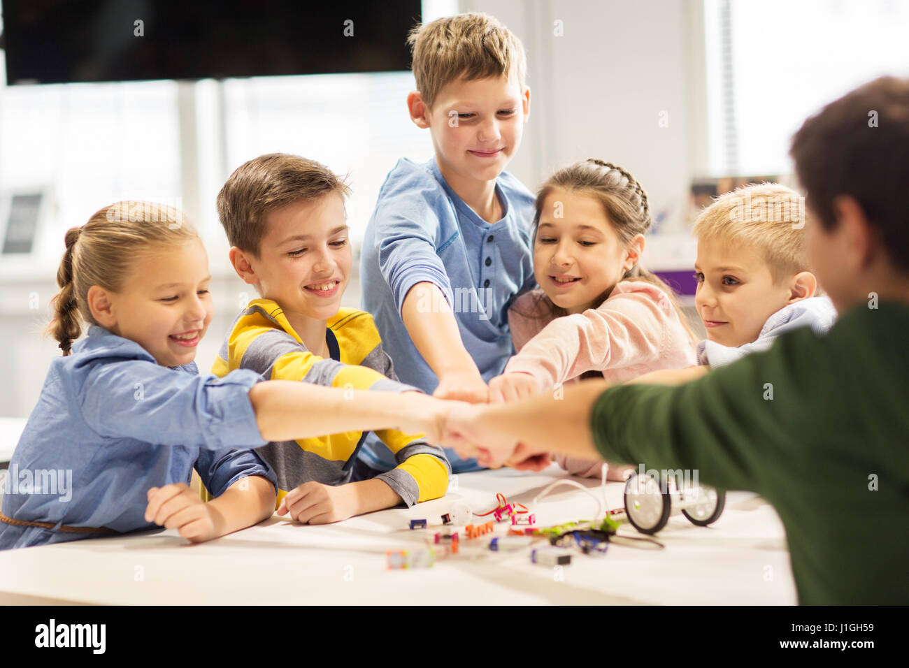 happy children making fist bump at robotics school Stock Photo - Alamy