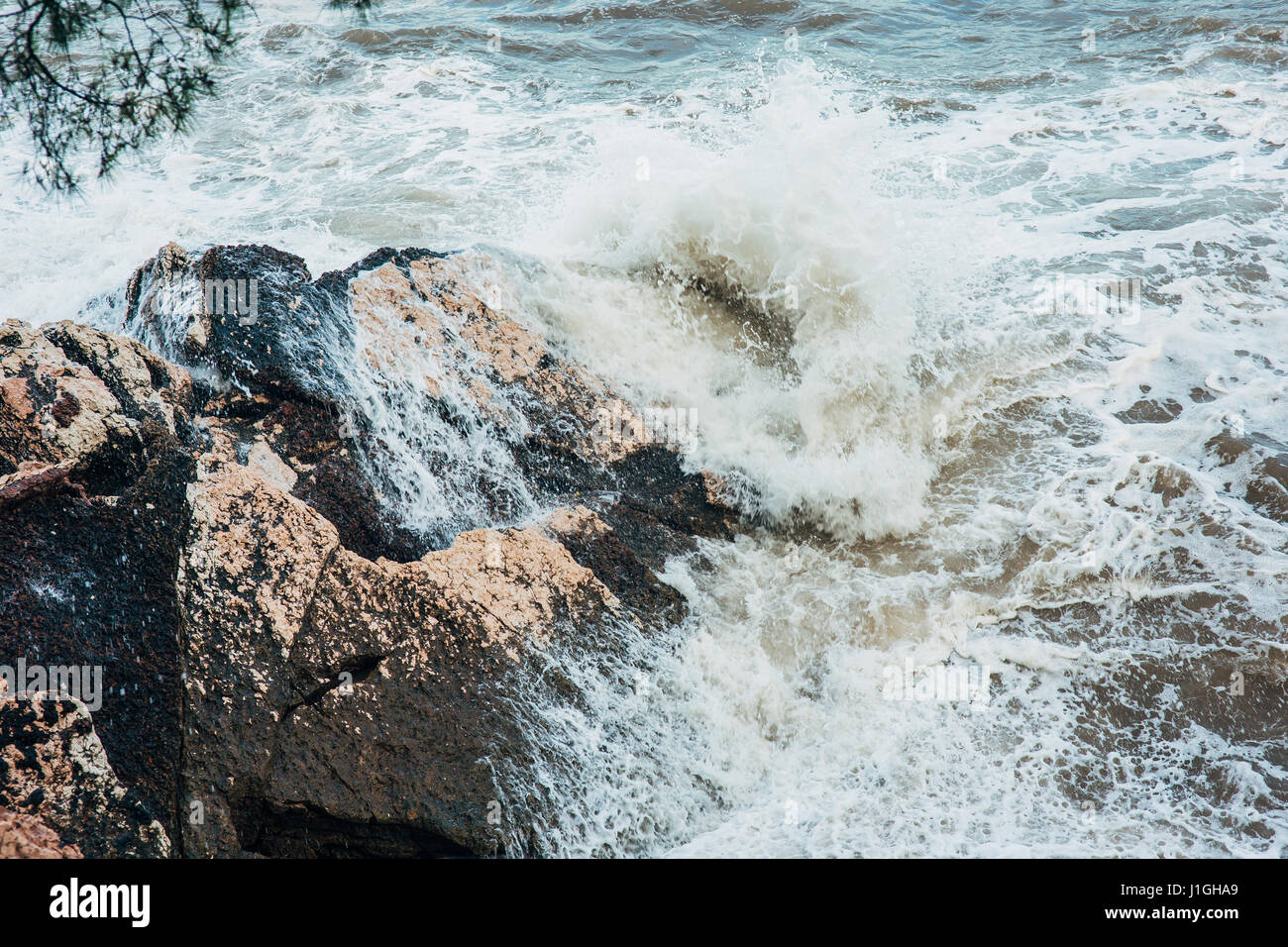 Rocks sticking out of the water and the waves washed Stock Photo - Alamy